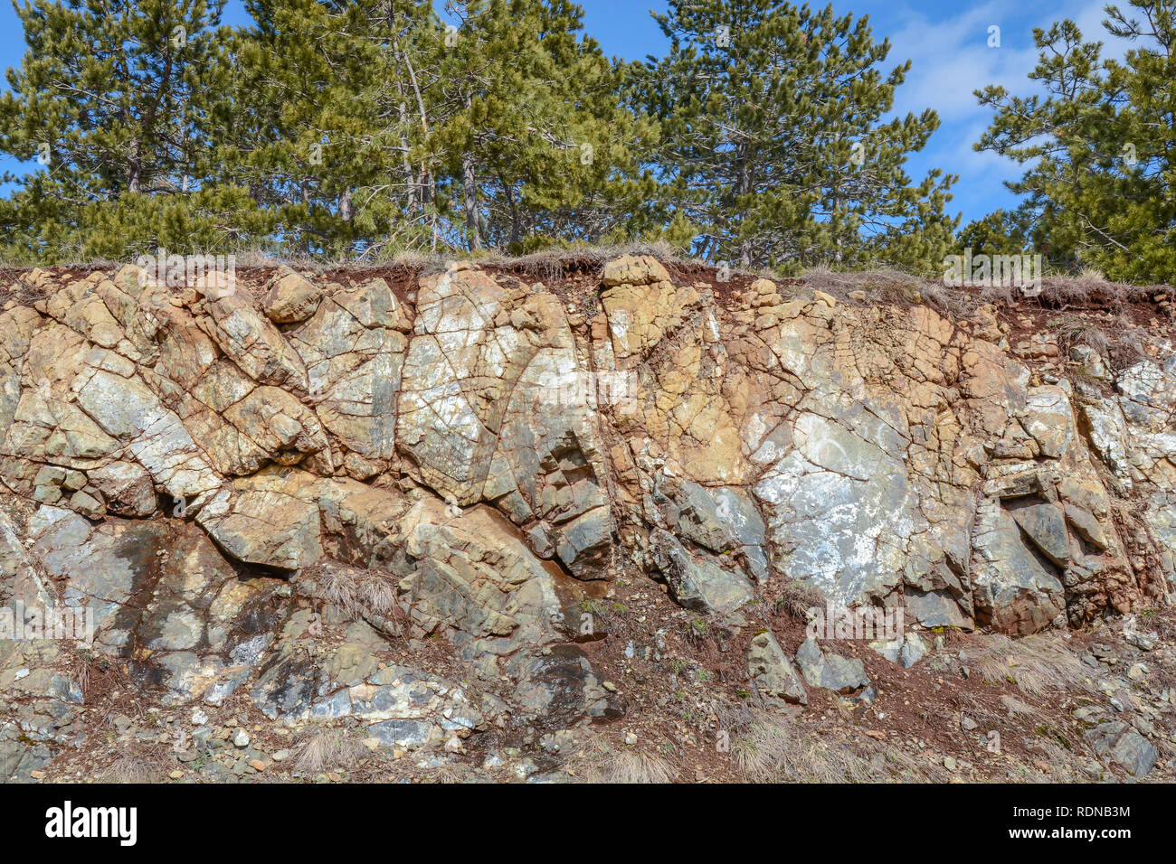 Mountain stone part with pine green tree on top of it with sky Stock ...