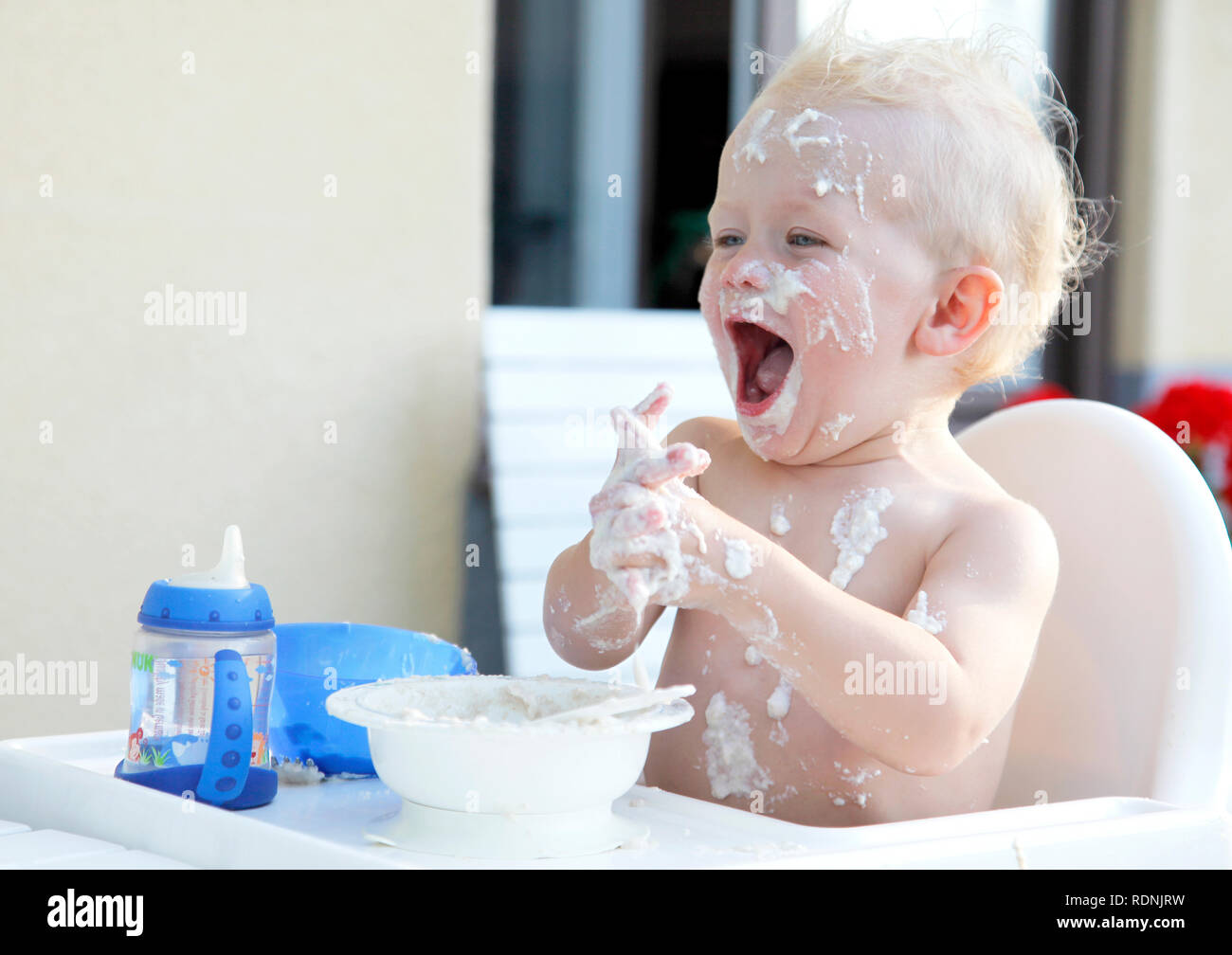 Baby learning how to eat Stock Photo - Alamy