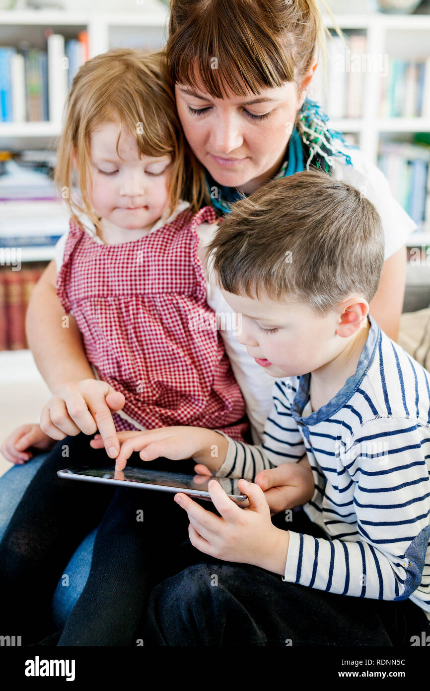 Mother and children vid a tablet Stock Photo - Alamy
