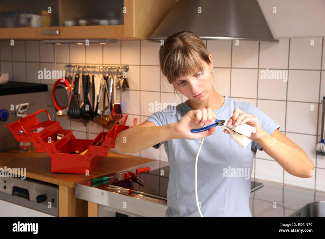 Young woman repairing a power cable plug Stock Photo - Alamy