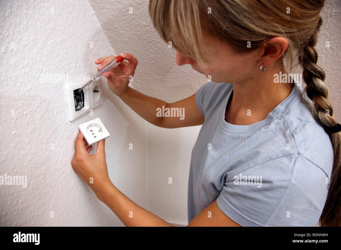 Young woman installing a power socket Stock Photo - Alamy