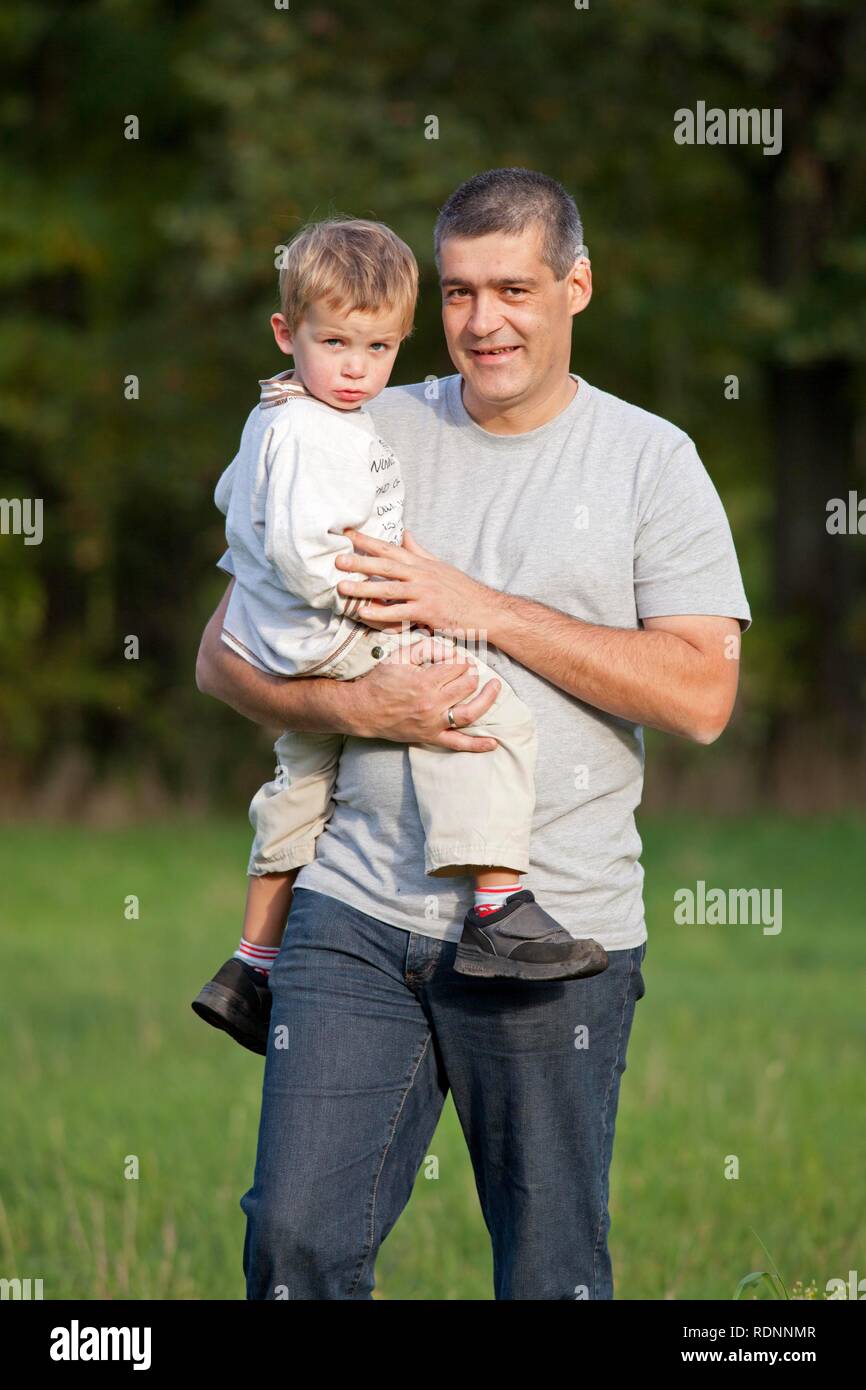 Father carrying his young son in his arms Stock Photo - Alamy