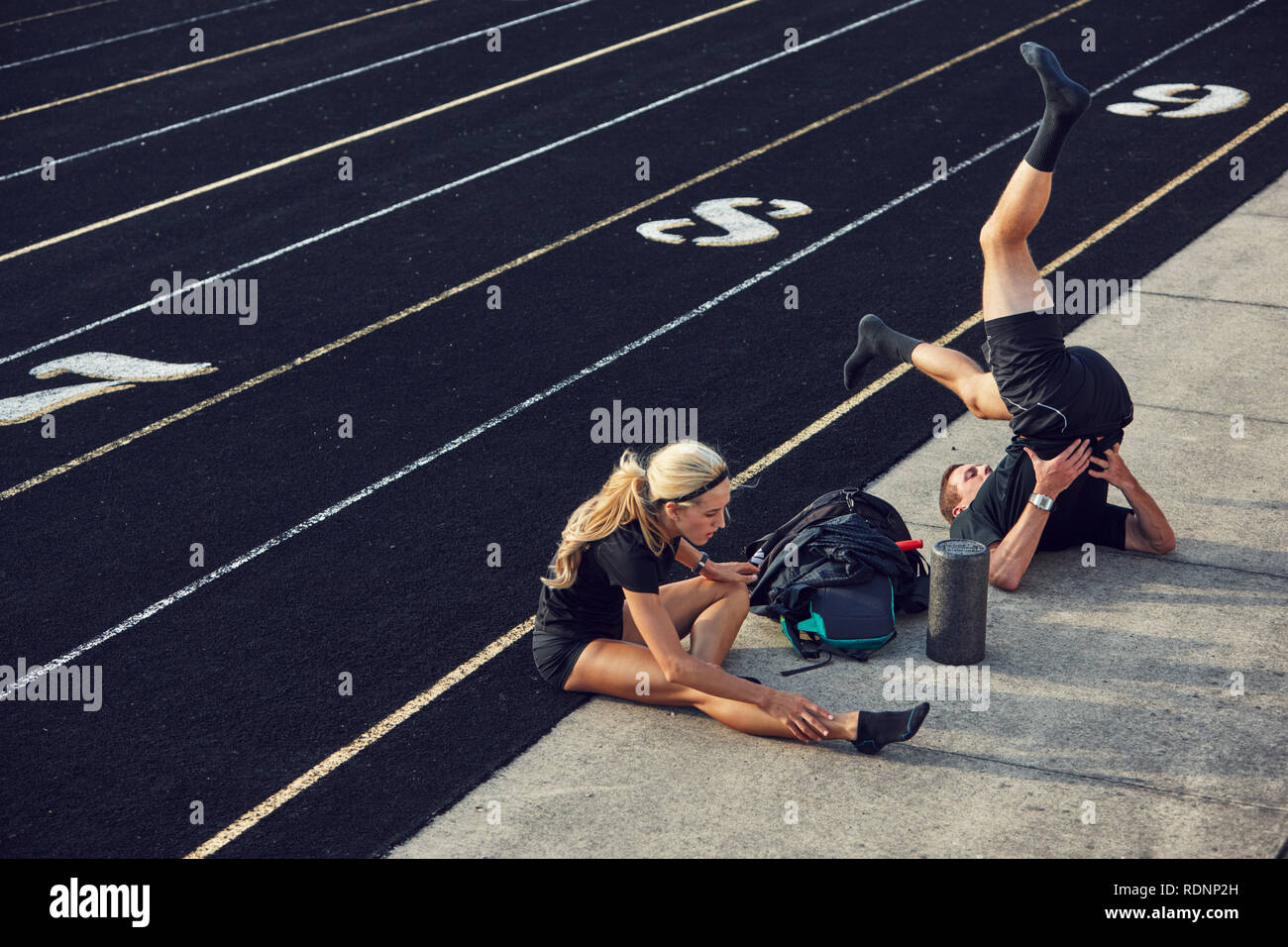 Athletes stretching at stadium Stock Photo - Alamy