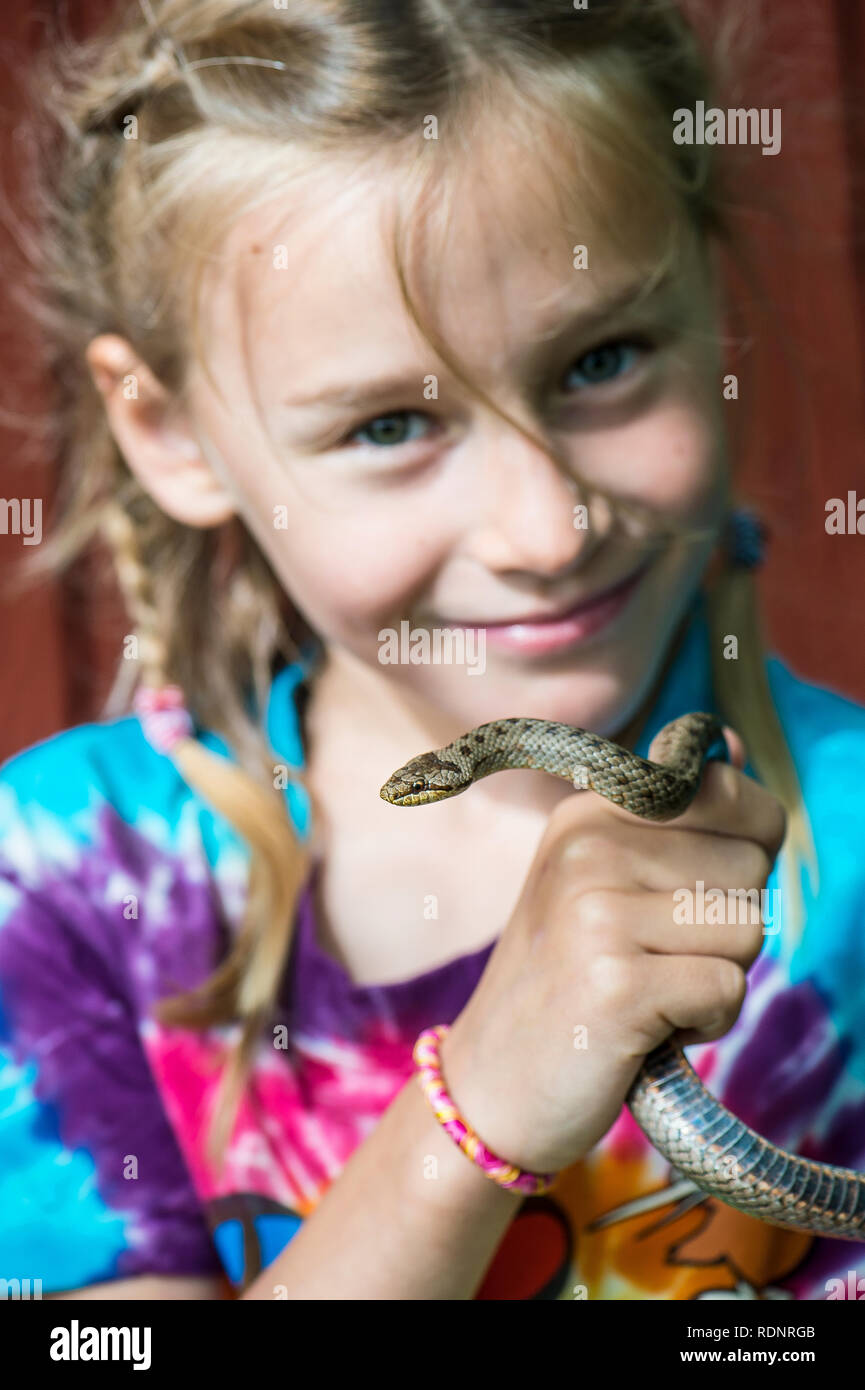 Girl holding snake Stock Photo - Alamy