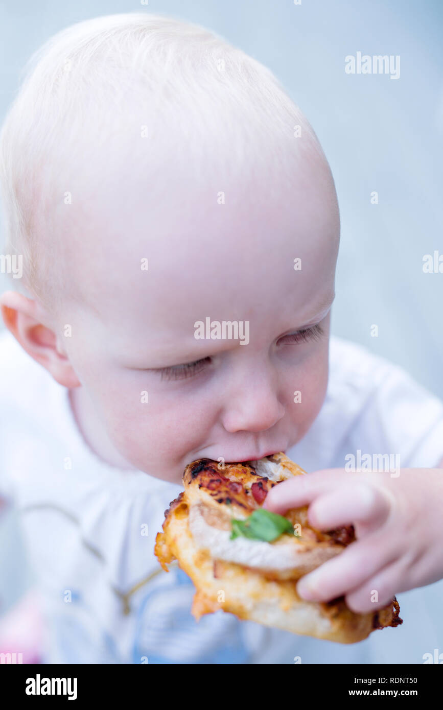 Boy eating grilled bun outdoors Stock Photo - Alamy