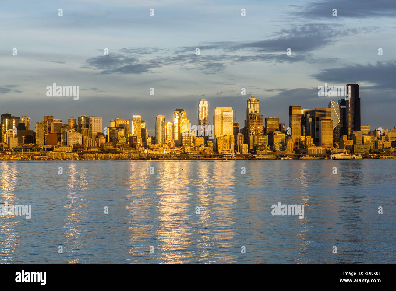 The setting sun is reflected from the skyscrapers in the Seattle ...