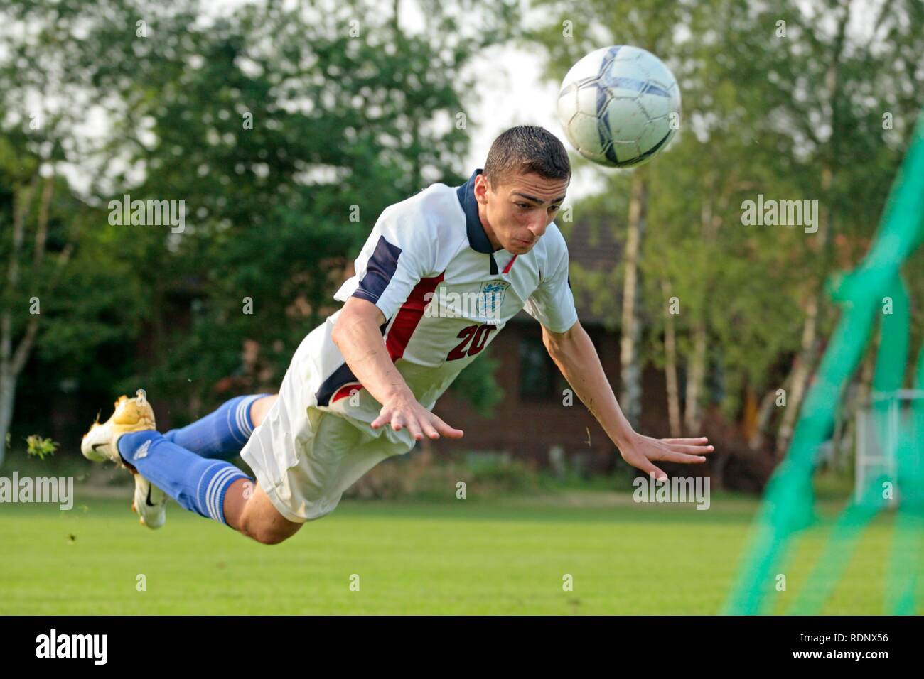 Boy heading a football at soccer practice Stock Photo - Alamy