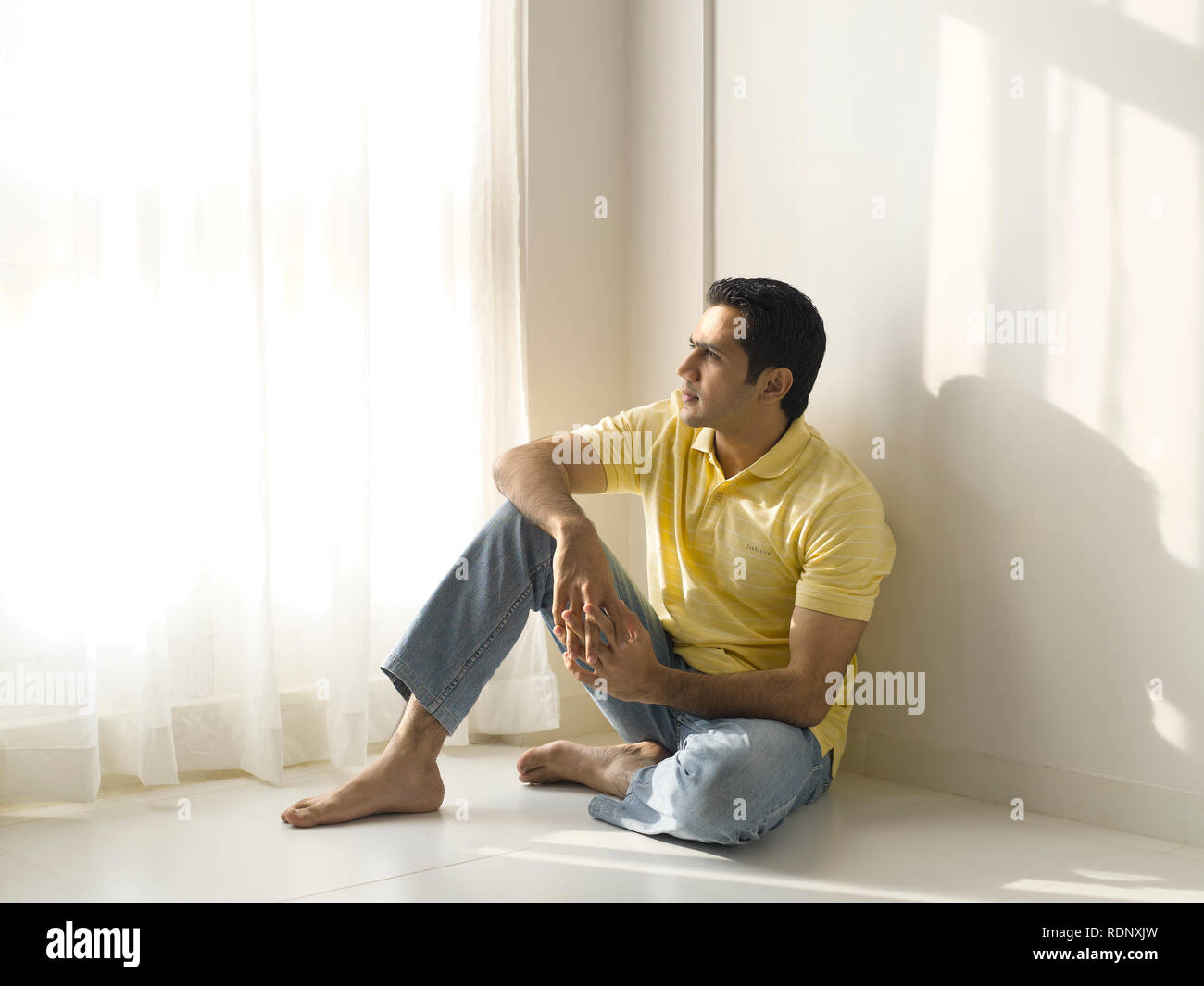 YOUNG MAN THINKING SITTING IN HIS HOME Stock Photo - Alamy