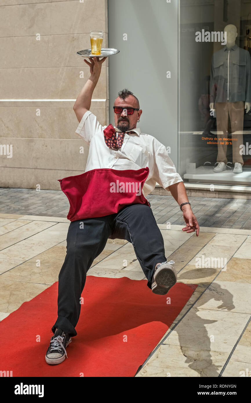 This is a human sculpture featuring a waiter falling down on the ...