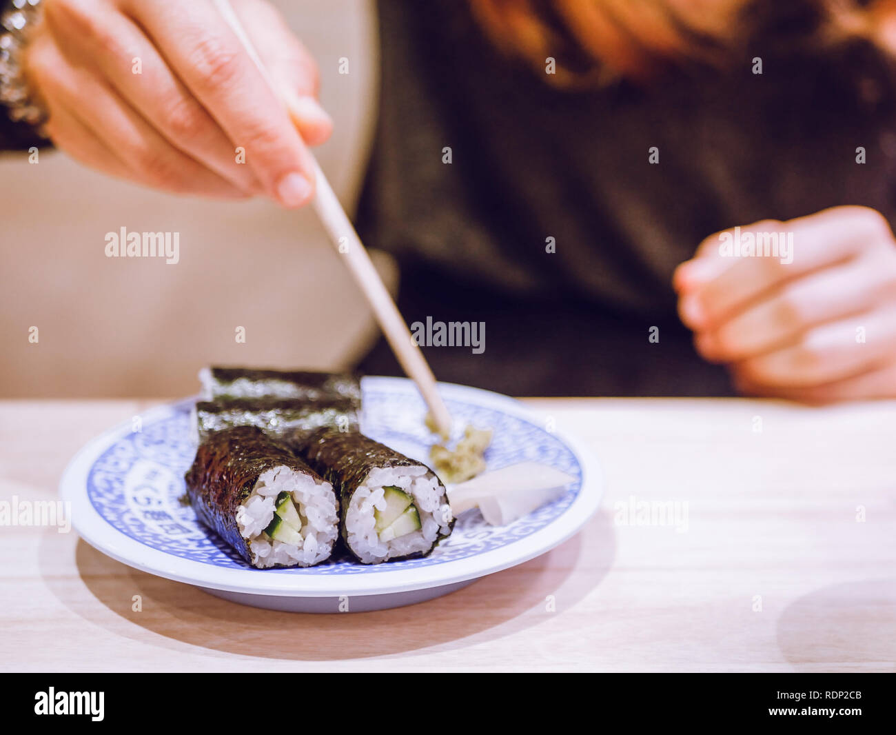 Using chopsticks to eat sushi from a plate Stock Photo - Alamy