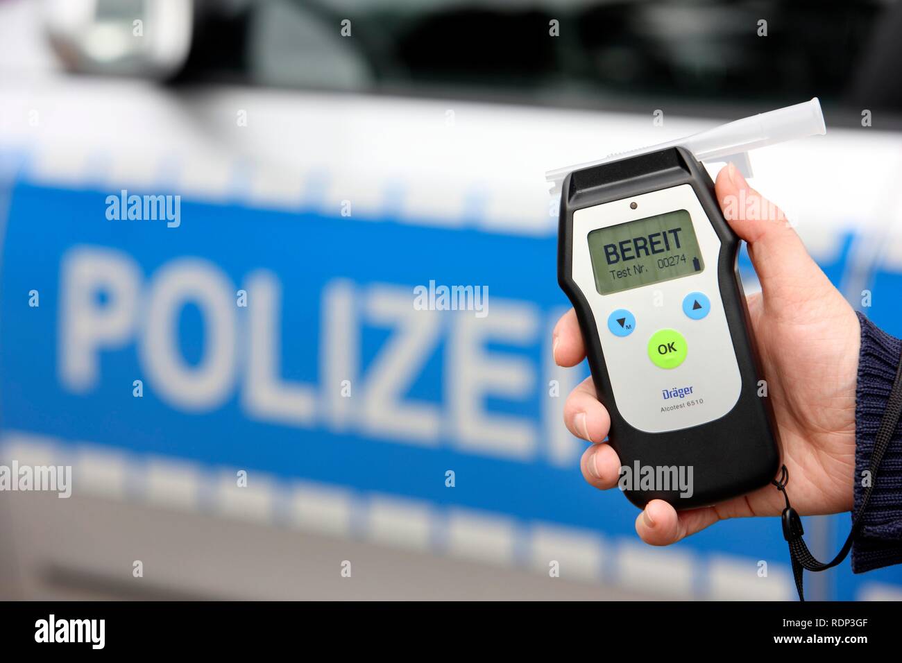Police officer with breathalyser for checking the fitness to drive ...