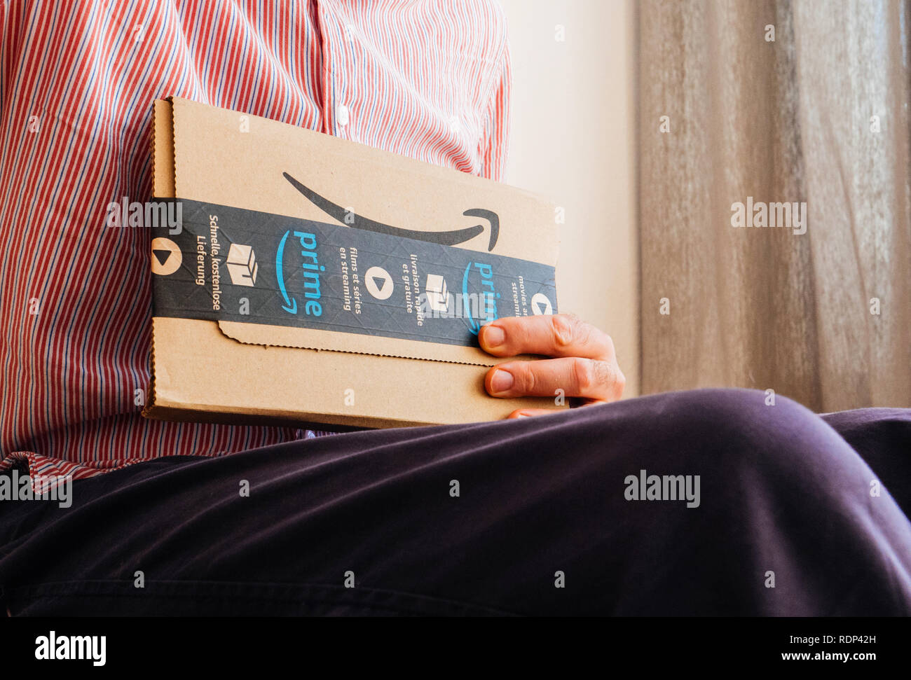 PARIS, FRANCE - JAN 28, 2016: Man unboxing box with Amazon logotype ...