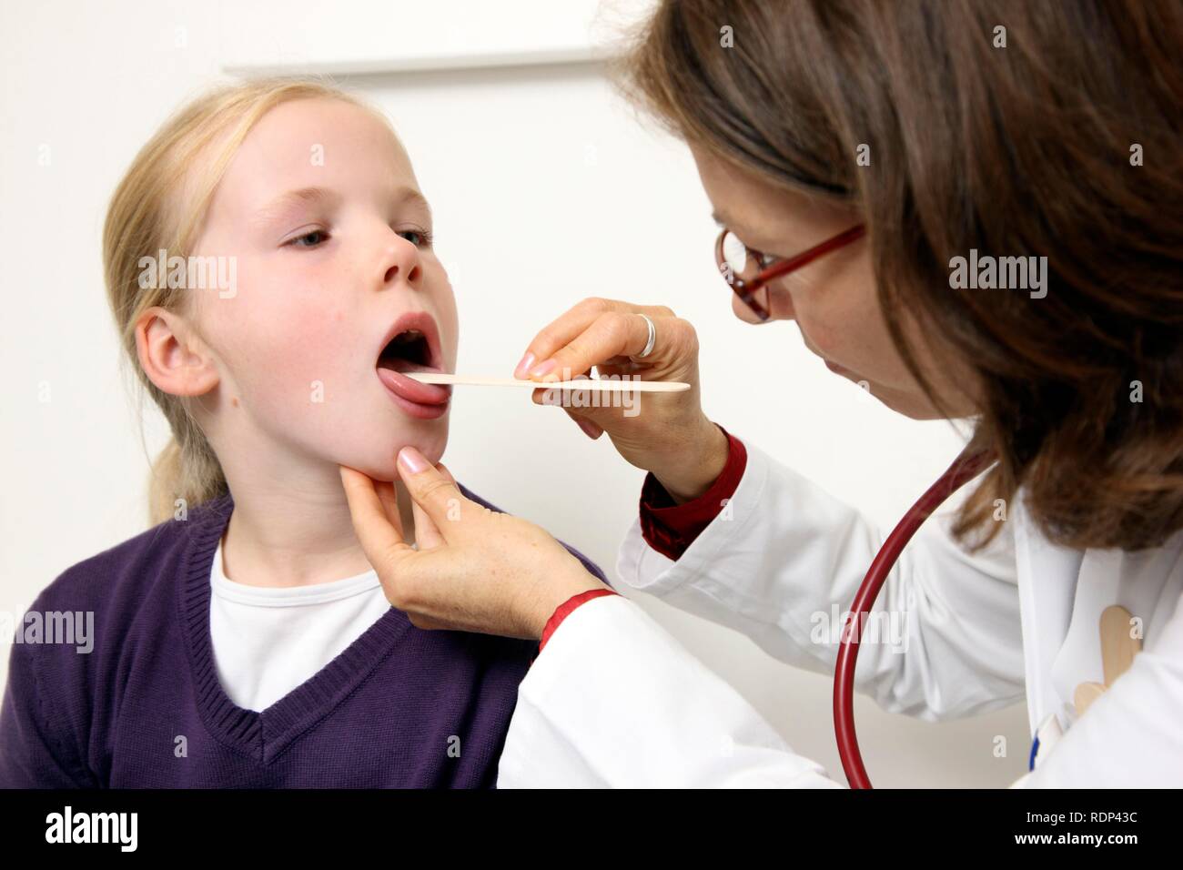 Medical practice, doctor and girl, 10 years, examination of the pharynx ...