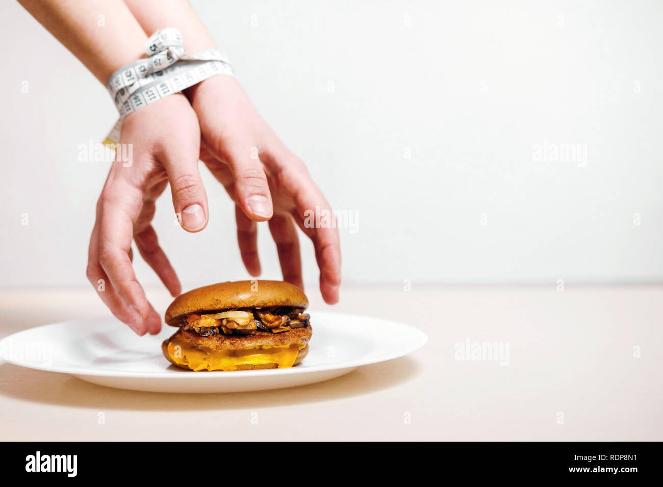 bound hands reaching for burger Stock Photo - Alamy