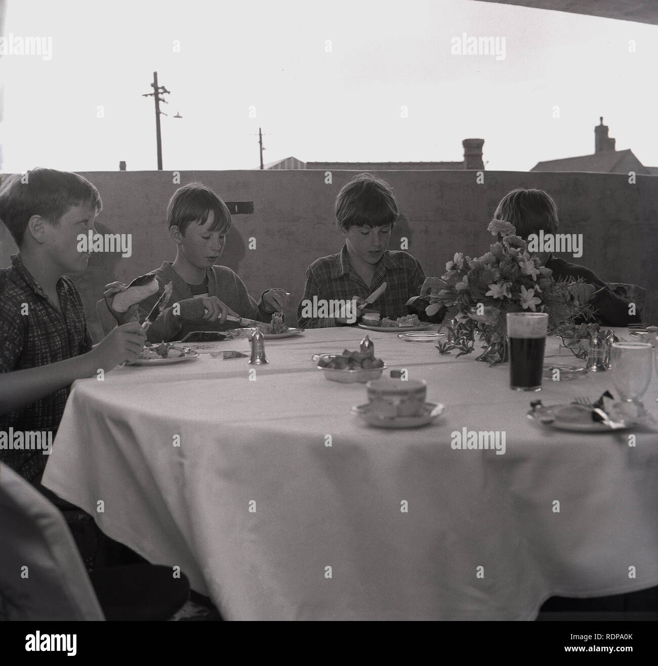 1967, historical, four young boys having a fancy tea on a cloth-covered ...