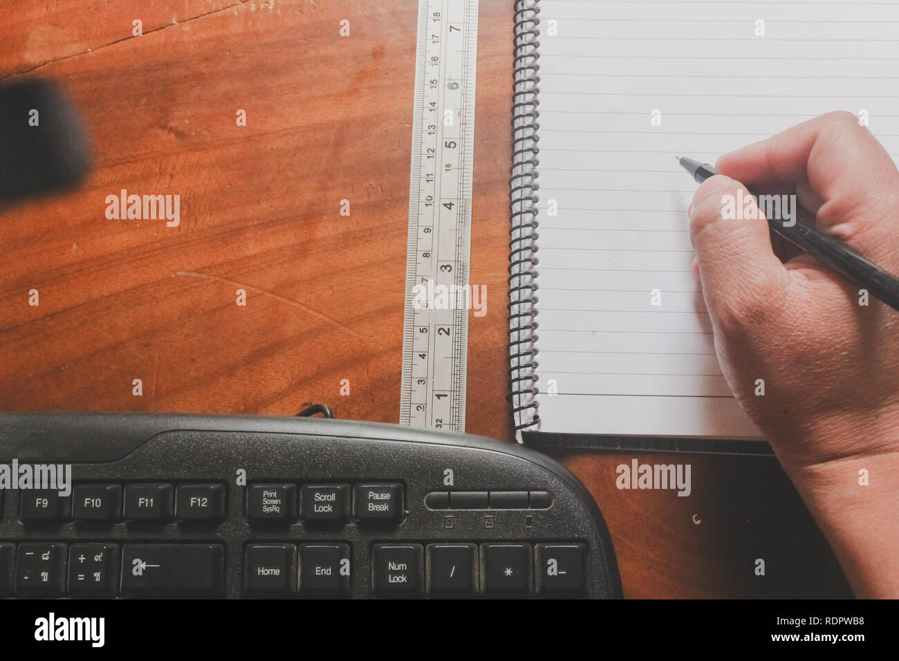 office supply close up on top view with hand hloding pen on book ruler ...
