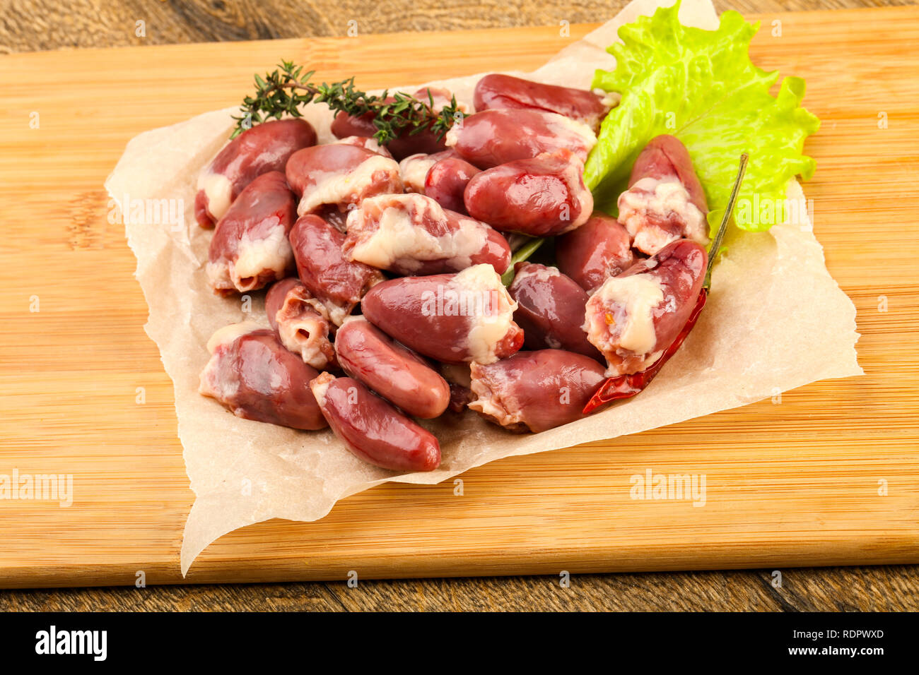 Raw chicken hearts heap with thyme branch Stock Photo - Alamy