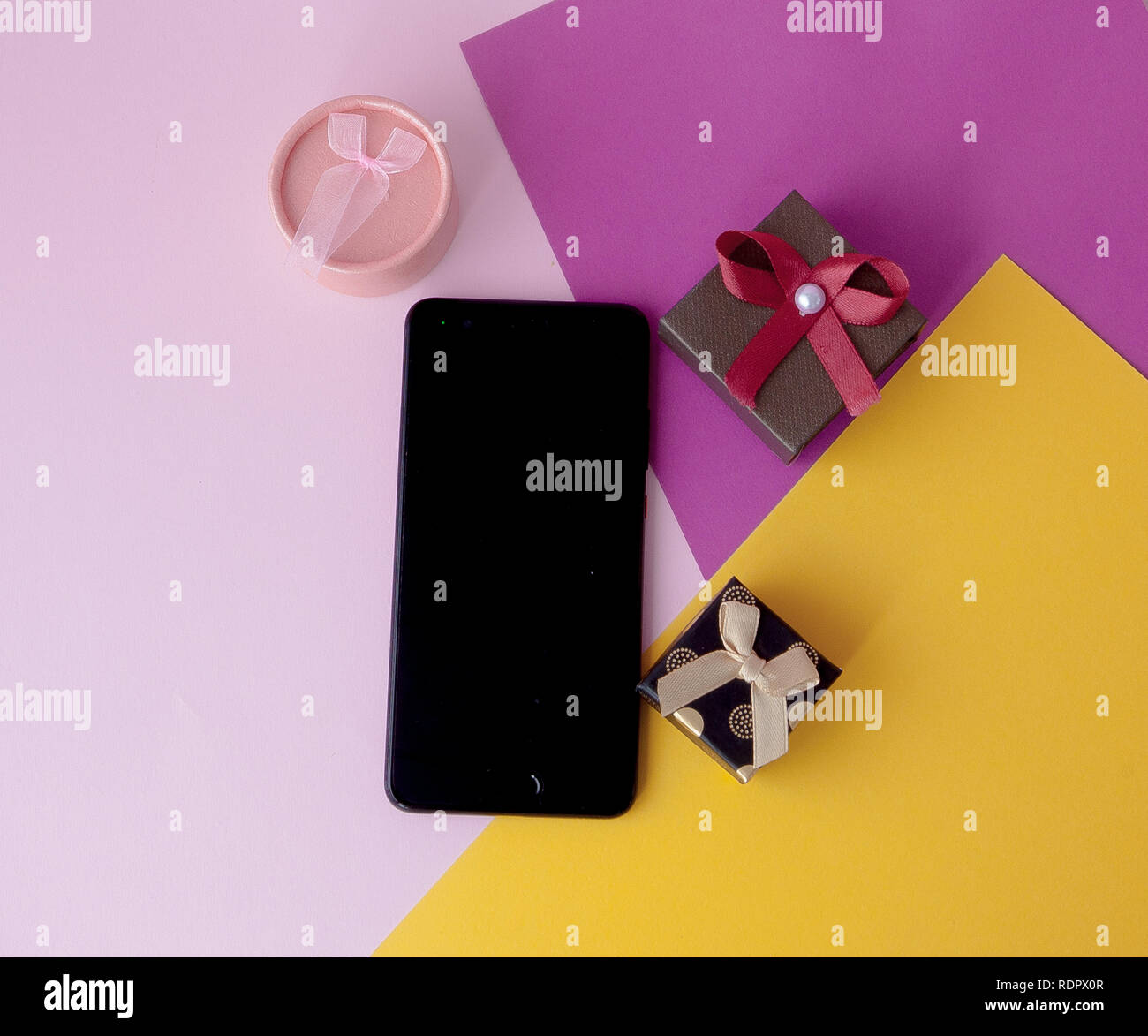 Phone screen and gifts on colored background. Minimal concept. Flat lay ...