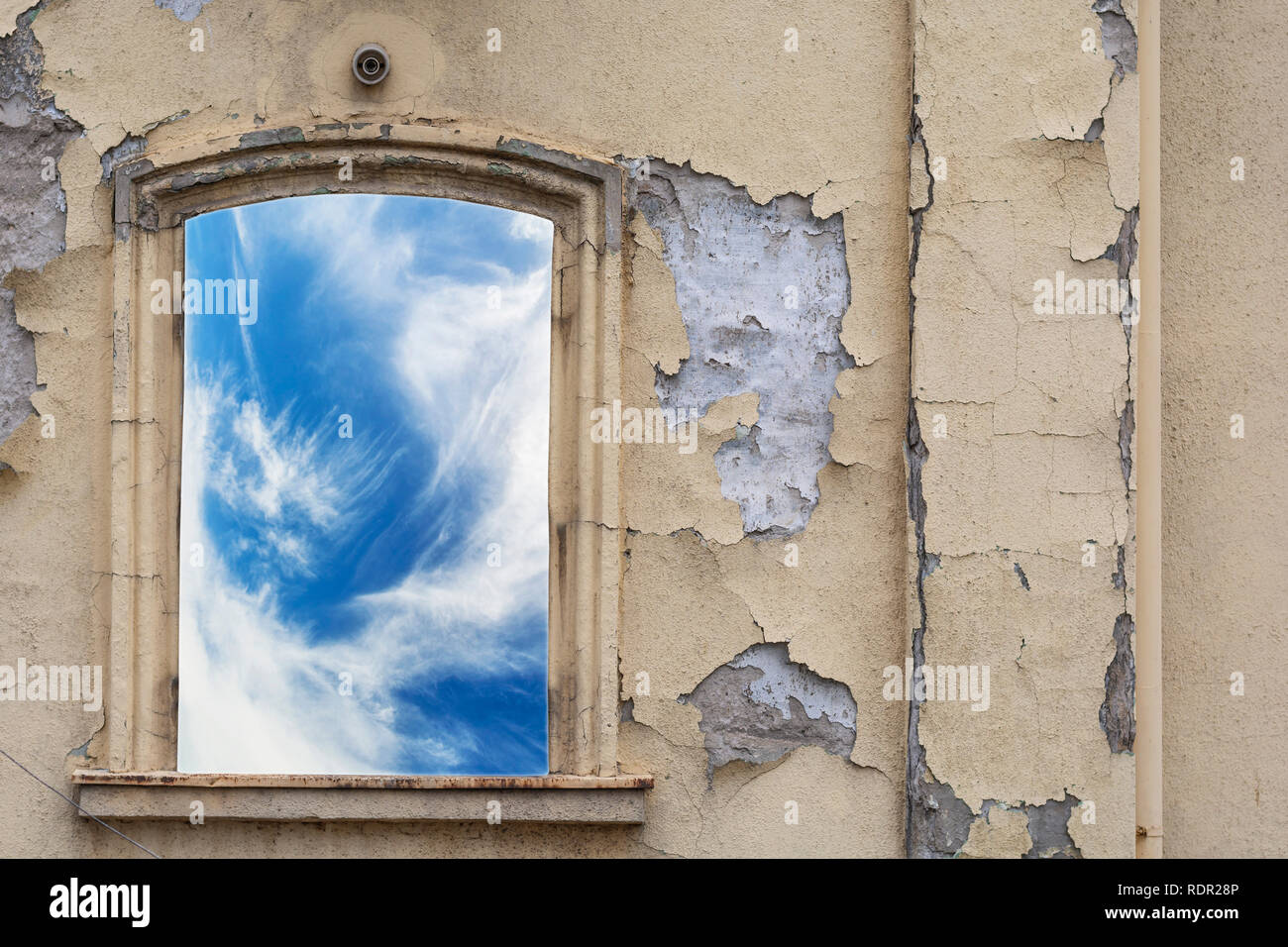 Old yellow dirty abandoned window house building wih blue cloudy sky ...