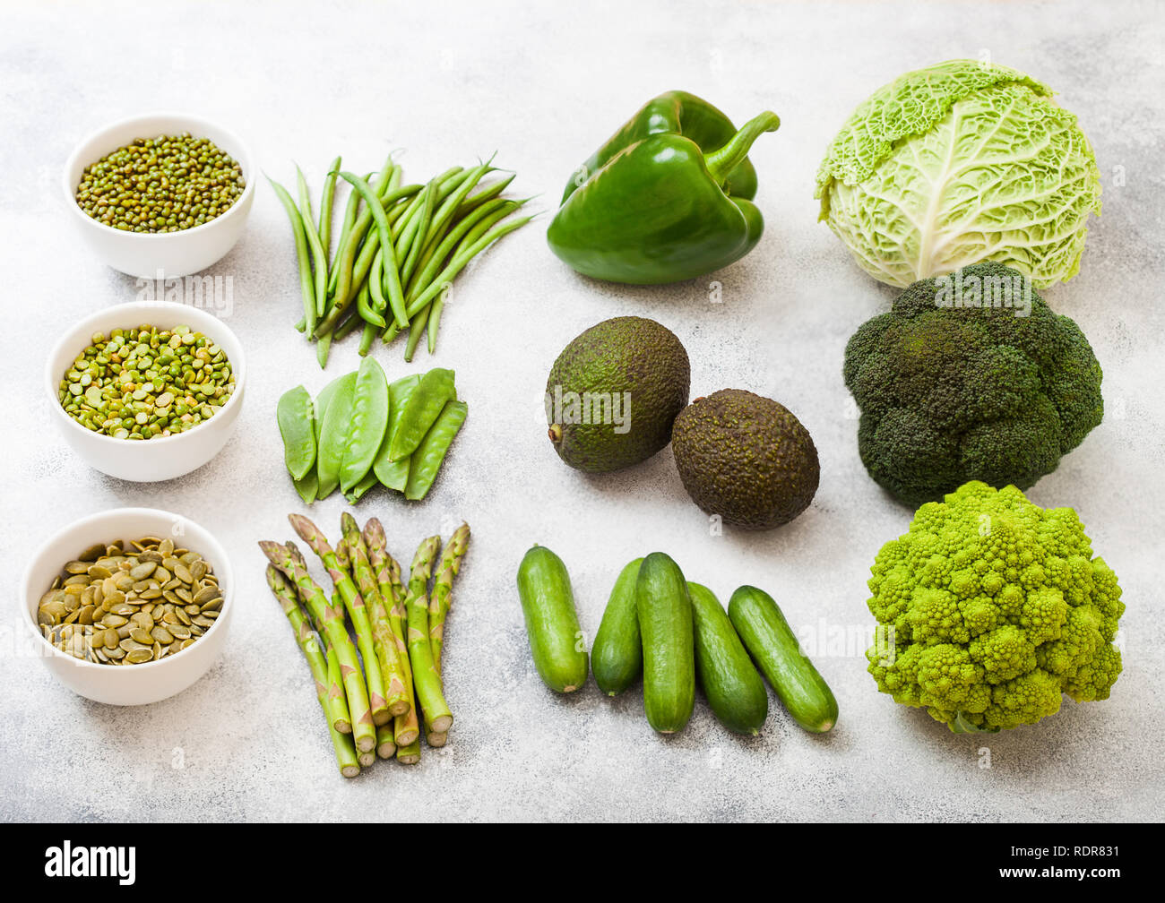 Assorted green toned raw organic vegetables on white background ...