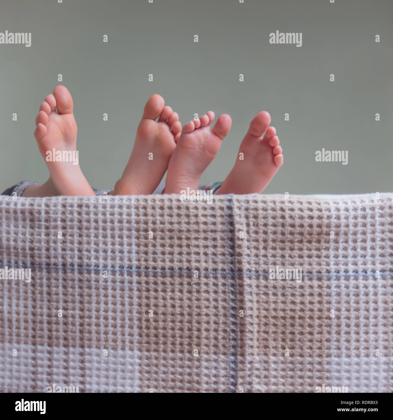 Children's feet. Barefeet on the bed. Kid's feet in bed. Kids taking a ...