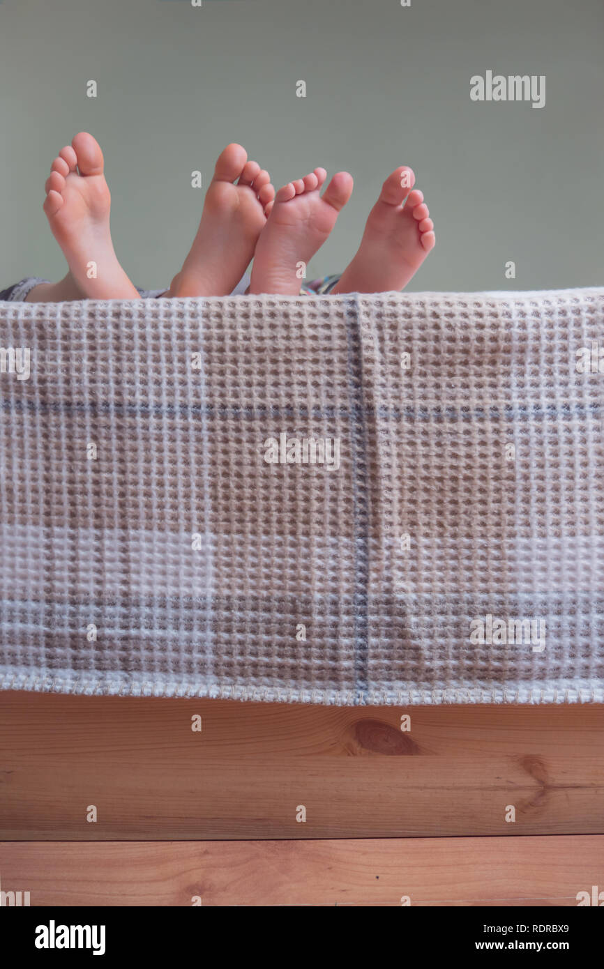 Children's feet. Barefeet on the bed. Kid's feet in bed. Kids taking a ...