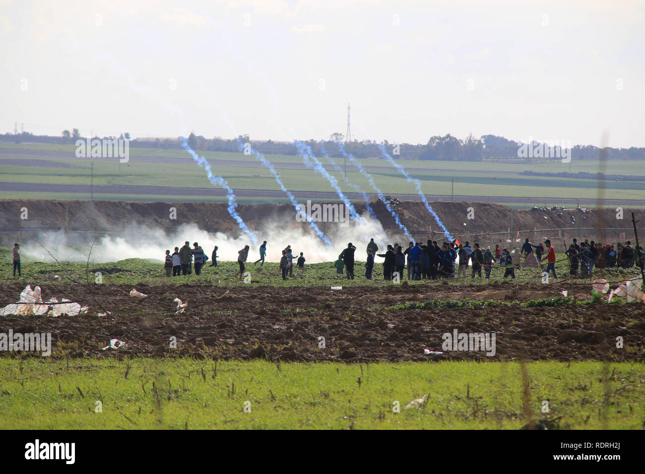 Palestinian demonstrators are seen throwing tear gas smoke canisters ...