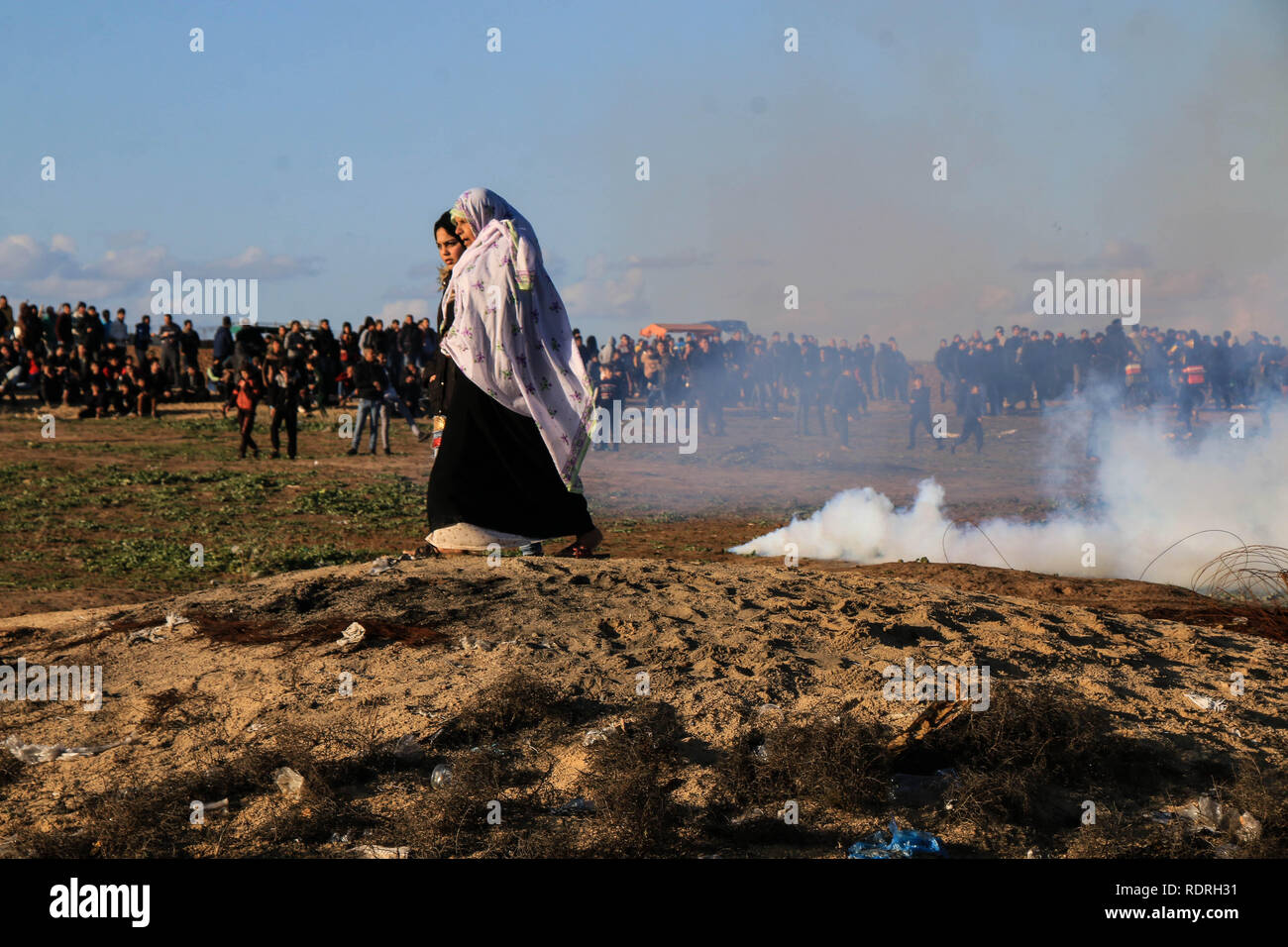 Palestinian demonstrators are seen before a tear gas smoke canisters ...