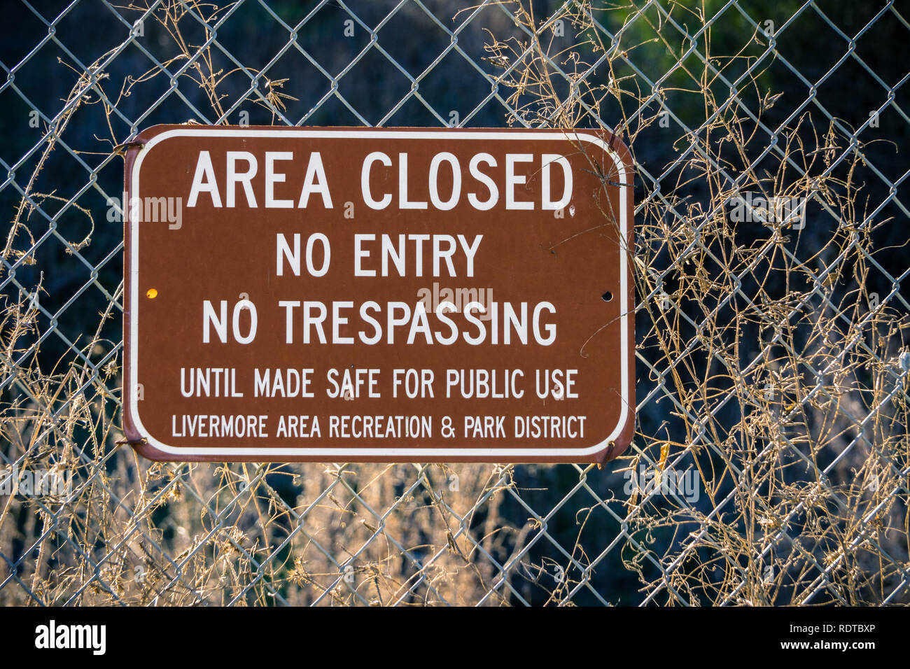 "Area closed, No entry, No trespassing" sign posted on a fence by ...