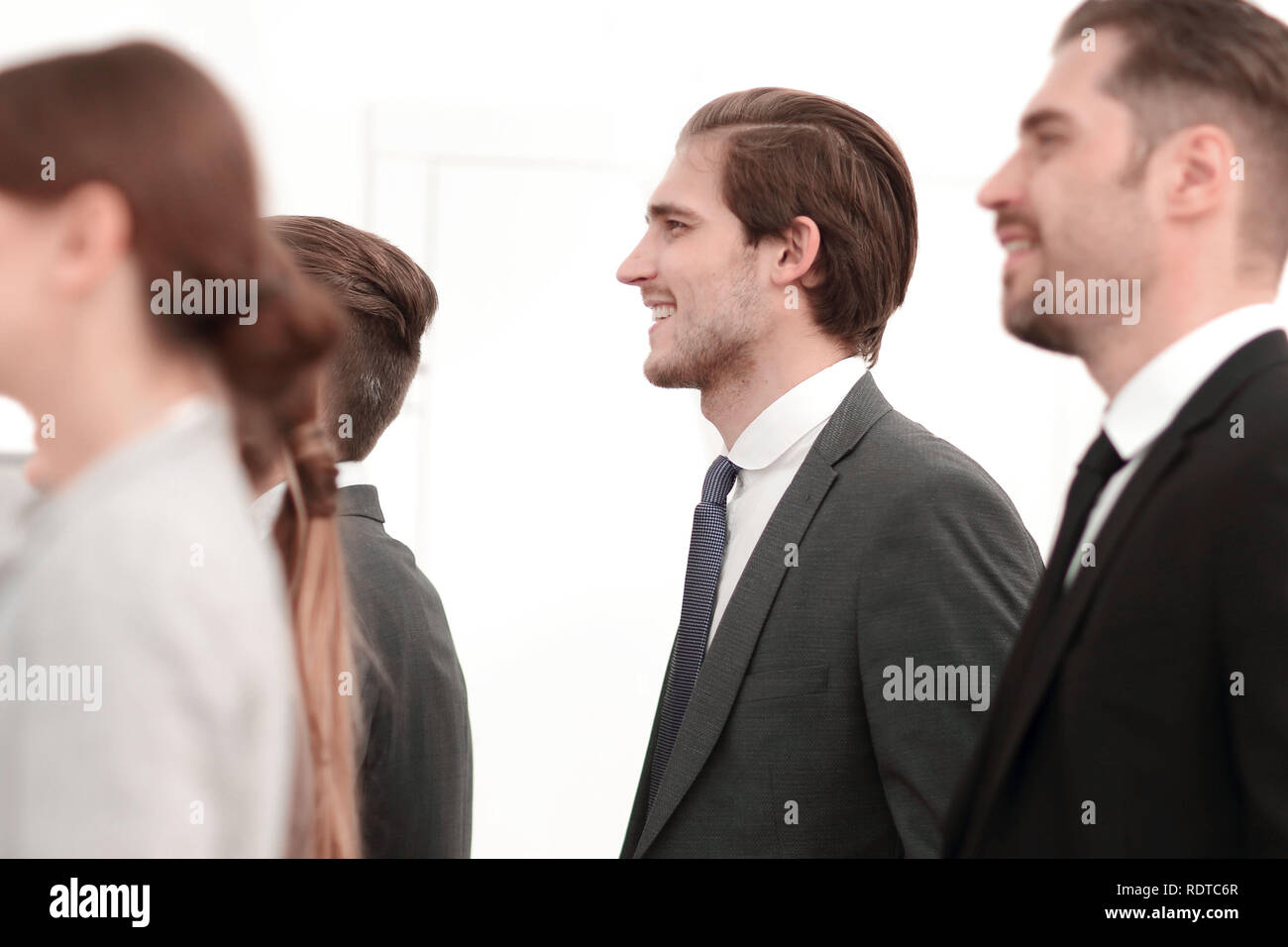 side view.a group of successful business people standing together.the ...