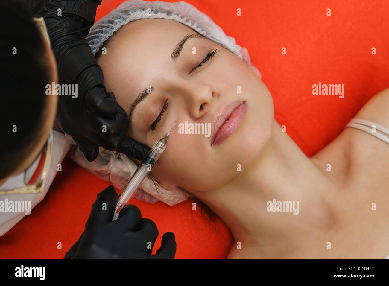 Beautician makes beauty injections in cheek area of face of woman ...