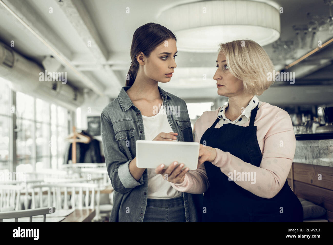 Dark-haired waitress wearing denim shirt speaking with employer Stock ...