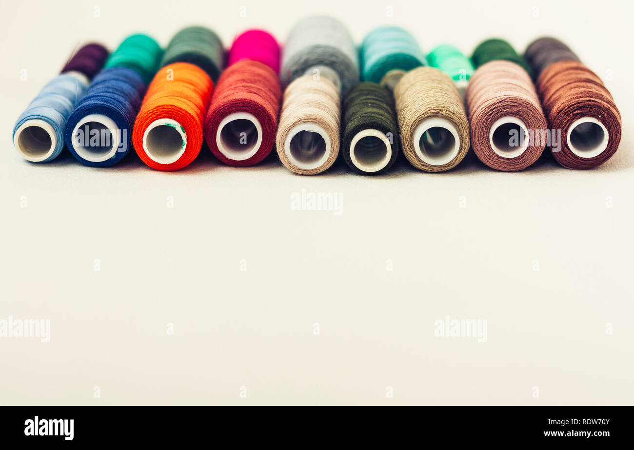 Colored sewing thread coils on white background with copy space for ...