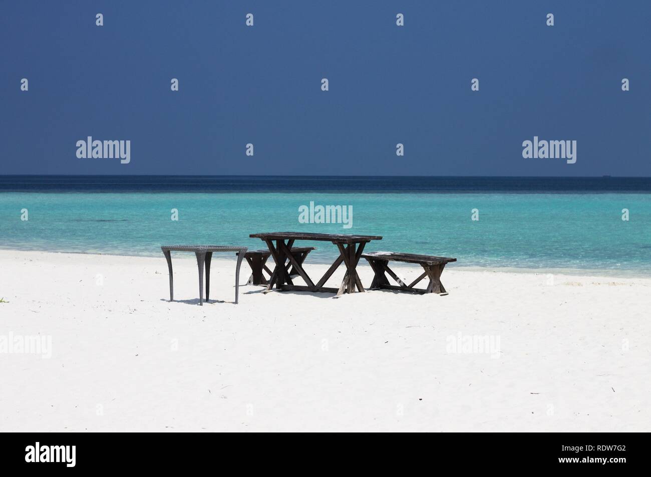 Picnic tables and bench on the shore of a desert island (Ari Atoll ...