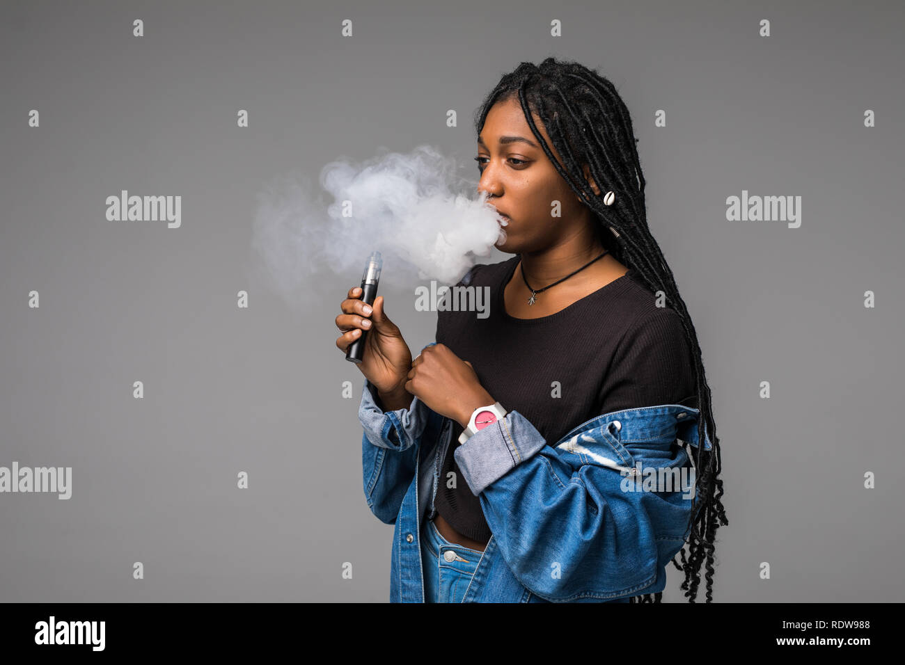Side view portrait of guy holding vape device and exhaling cloud of ...