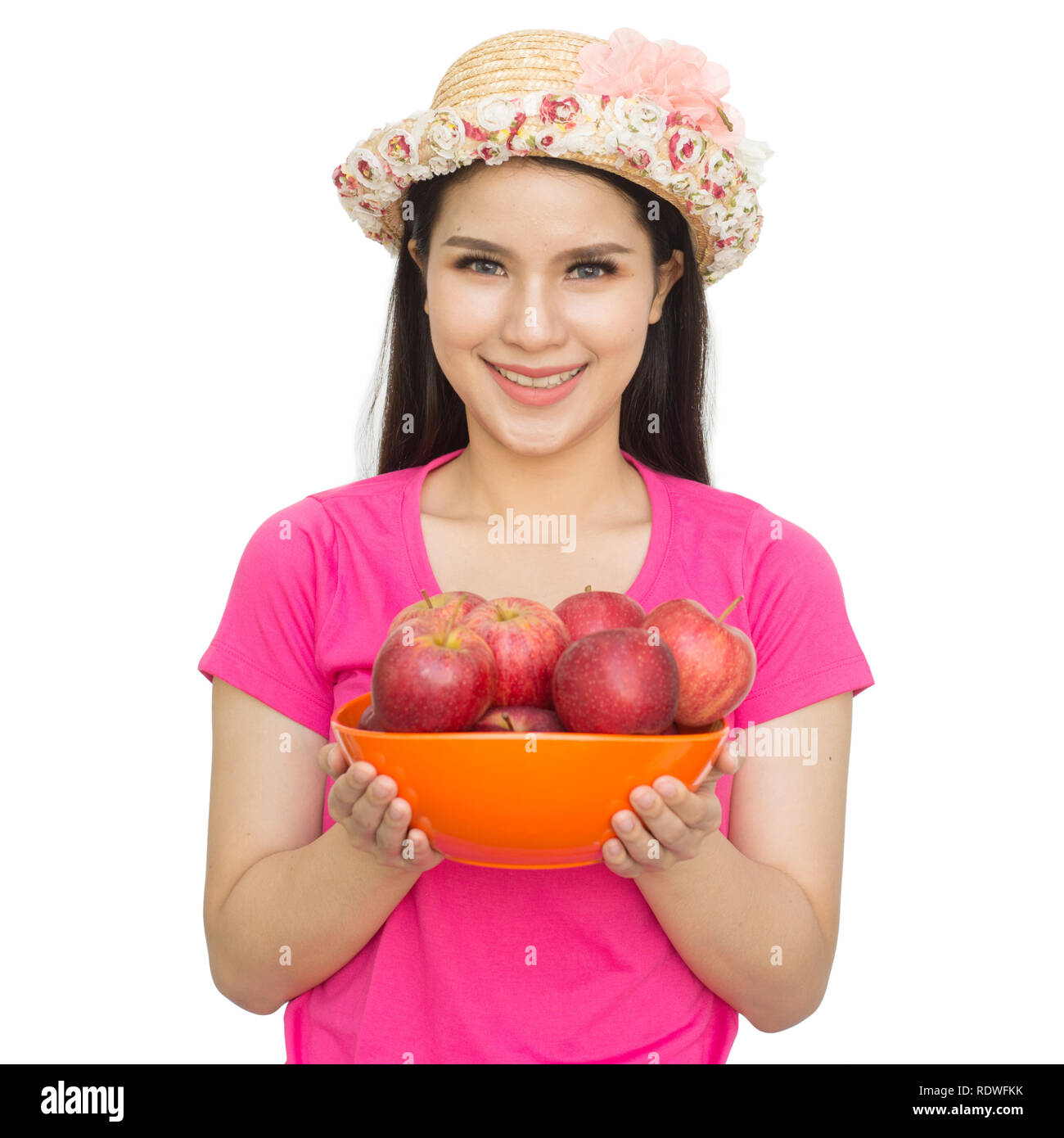Portrait of lovely young woman holding a fresh ripe apple in bowl and ...