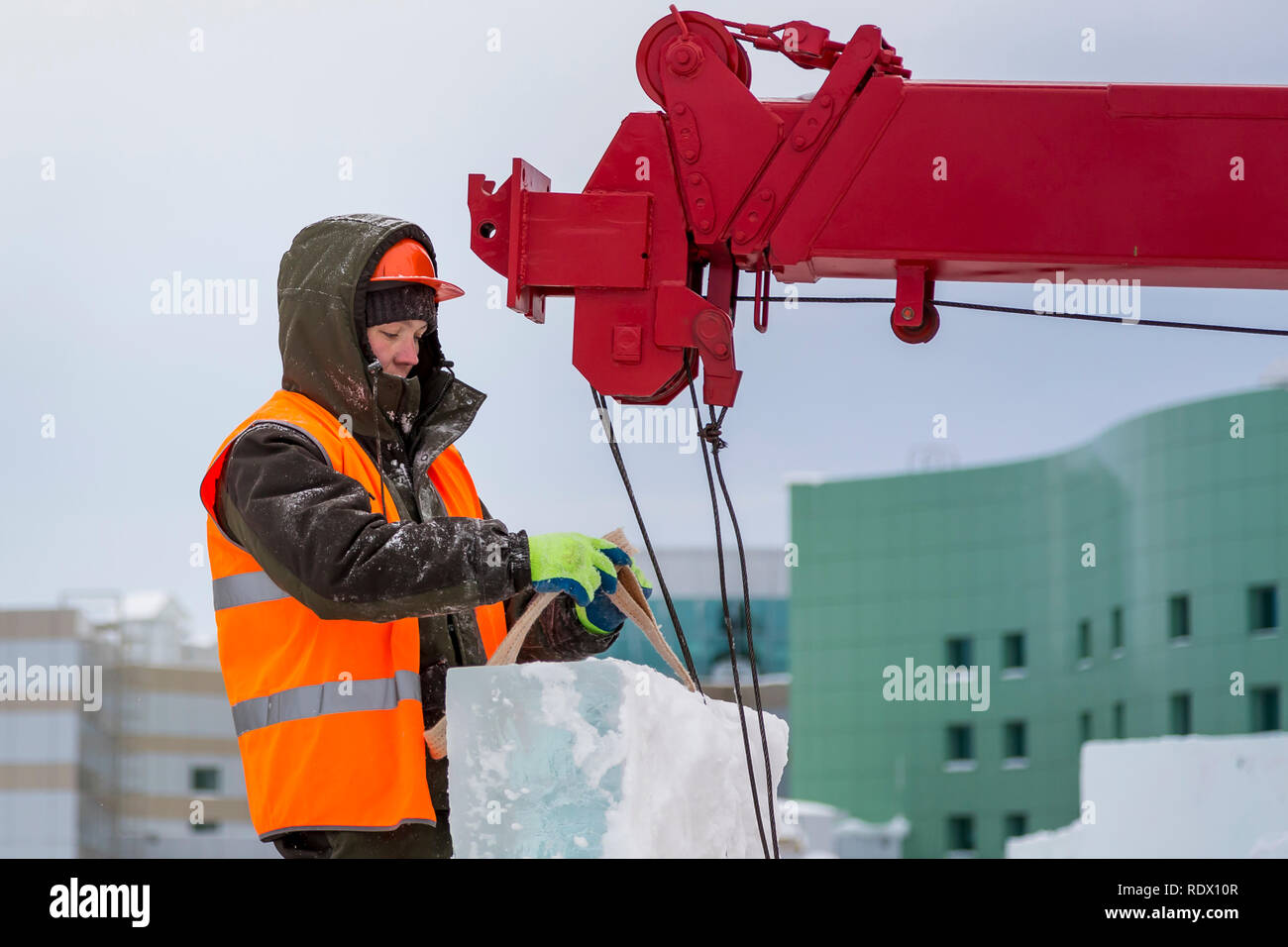 Portrait of a fitter slinger in an orange vest and helmet on unloading ...