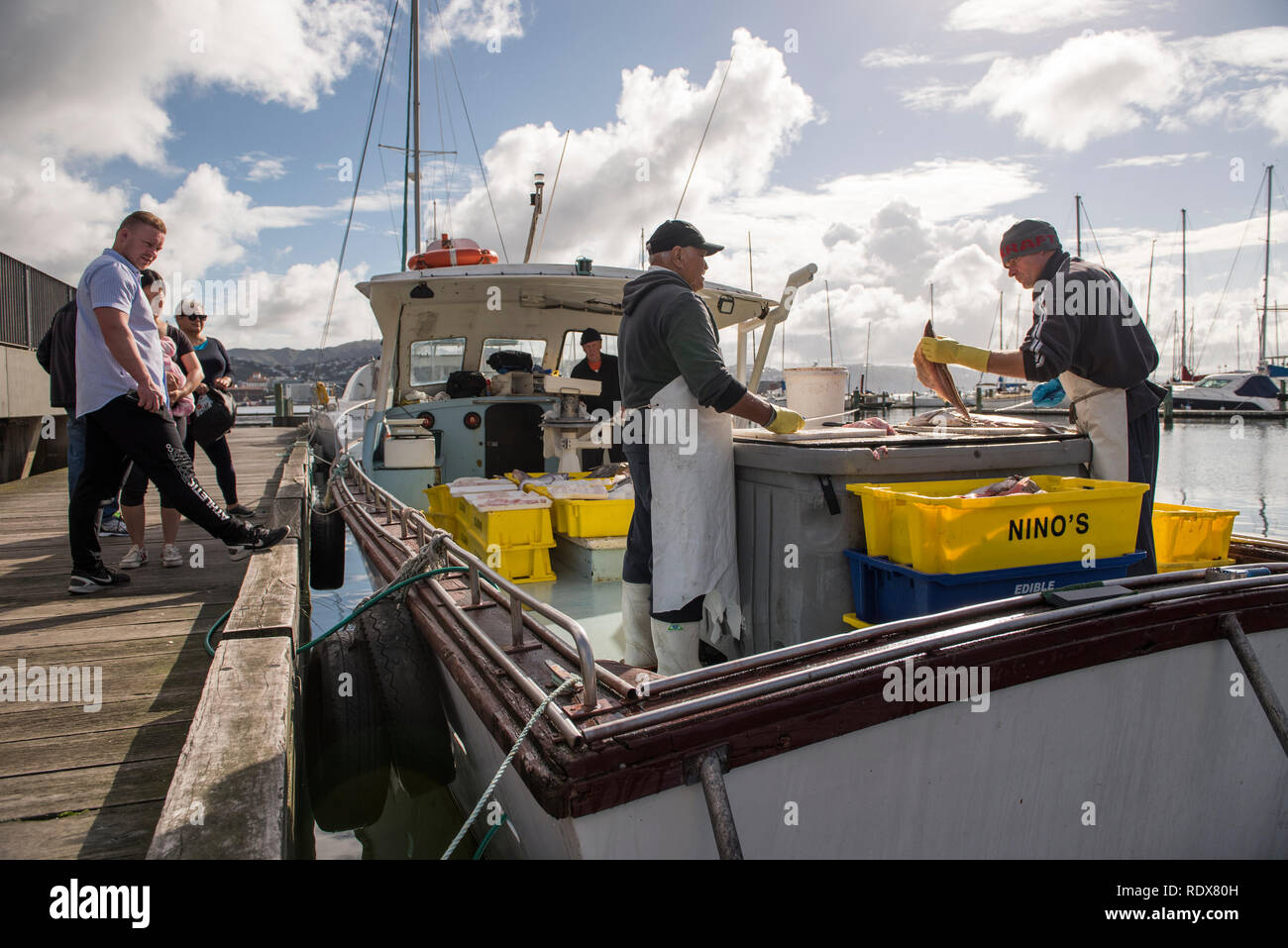 Fishermen selling fish directly from their boat while docked on the ...