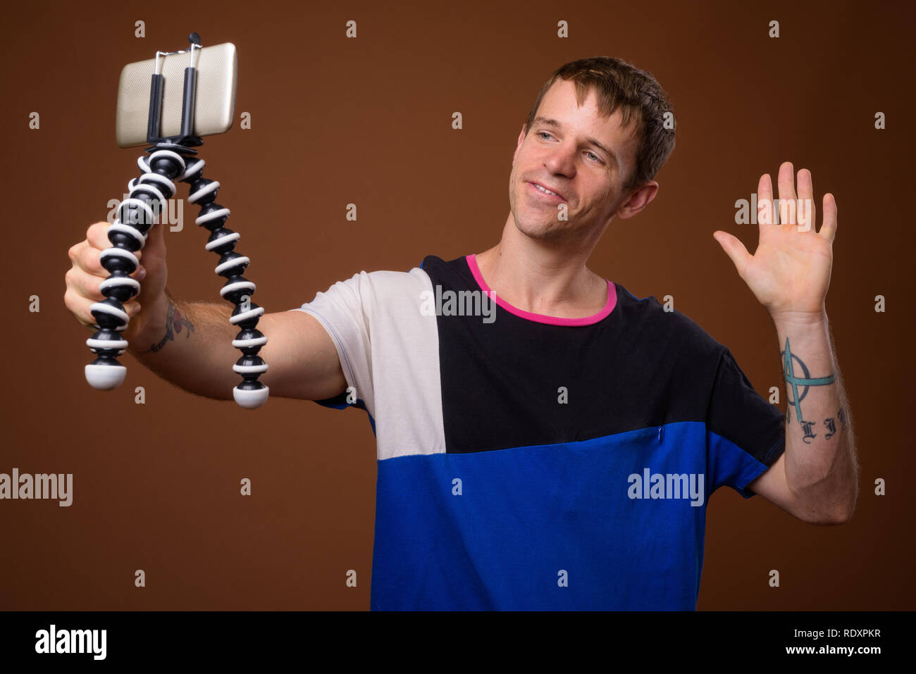 Man vlogging with mobile phone while wearing blue shirt against Stock ...