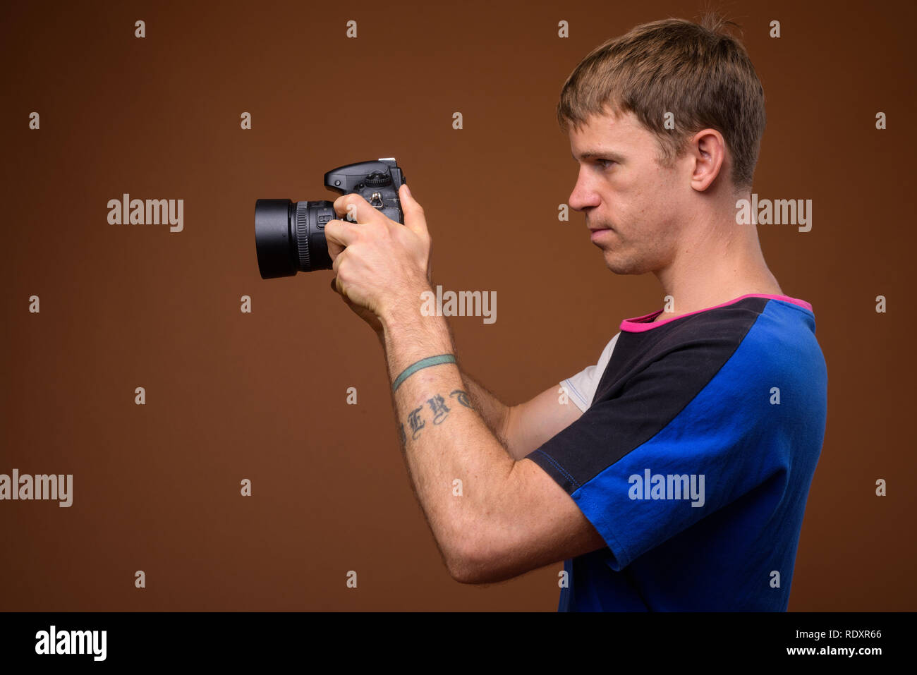 Portrait of photographer man using DSLR camera in studio Stock Photo ...
