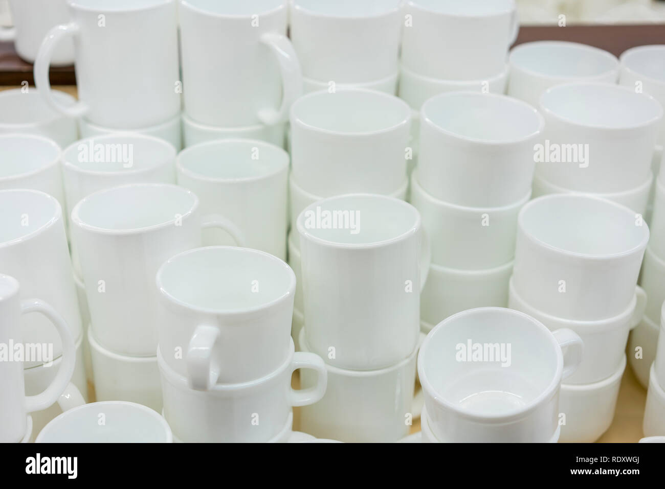 White cups on the shelf in the store. White ceramic coffee cups and ...