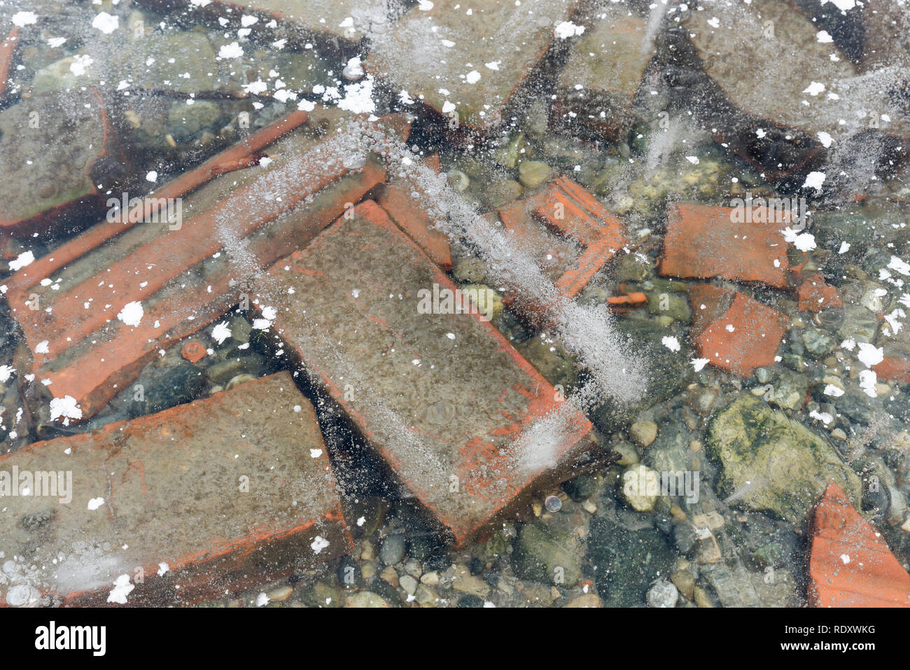 Winter background. Bricks and stones under the ice Stock Photo - Alamy