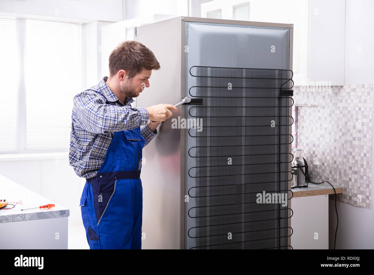Electrician working on fridge in home hi-res stock photography and ...