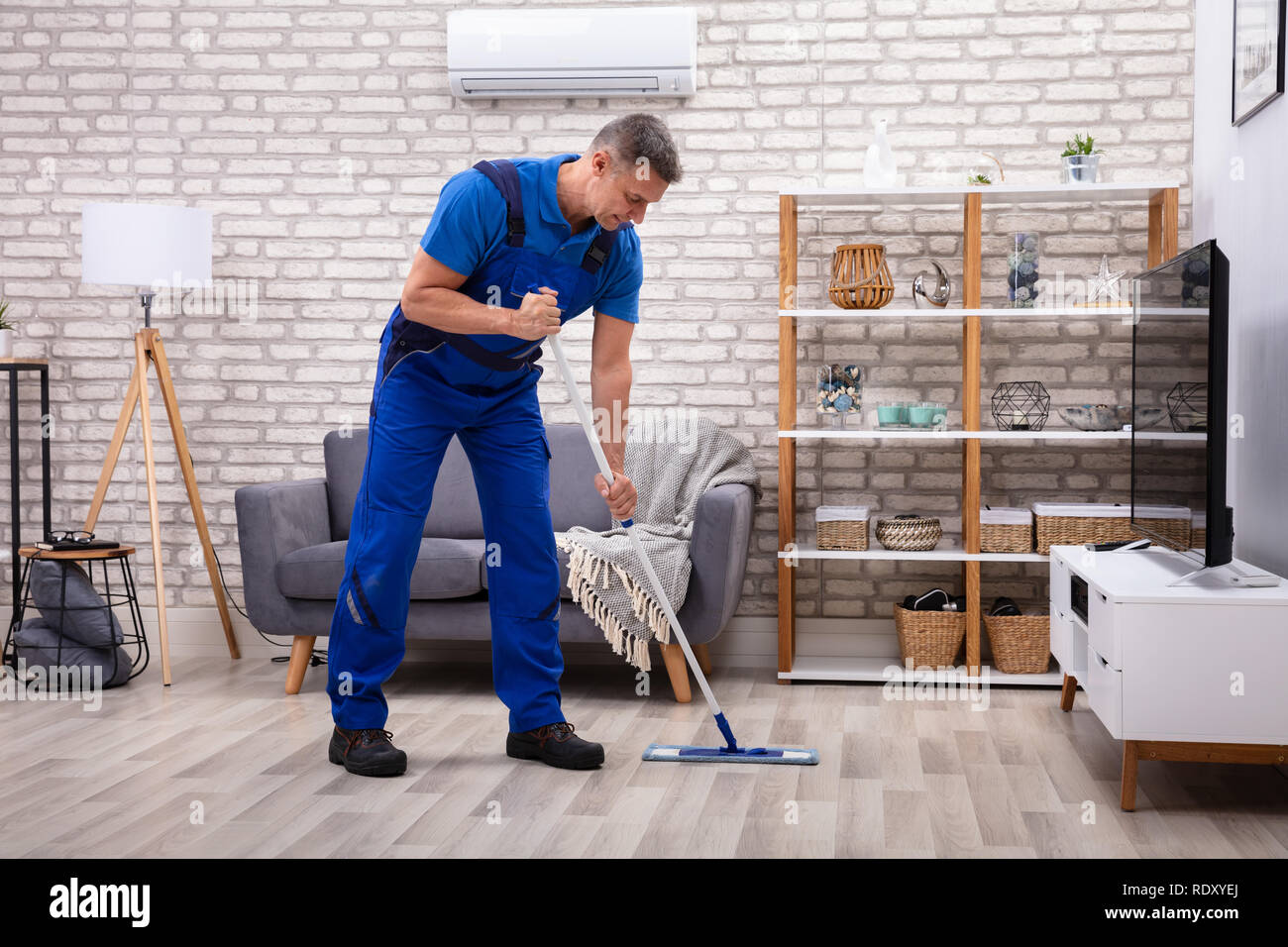 Mature Male Janitor Cleaning Floor With Mop At Home Stock Photo - Alamy