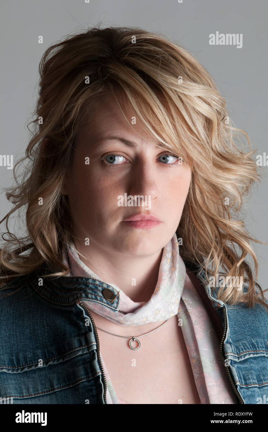 Serious blond woman looking away Stock Photo - Alamy
