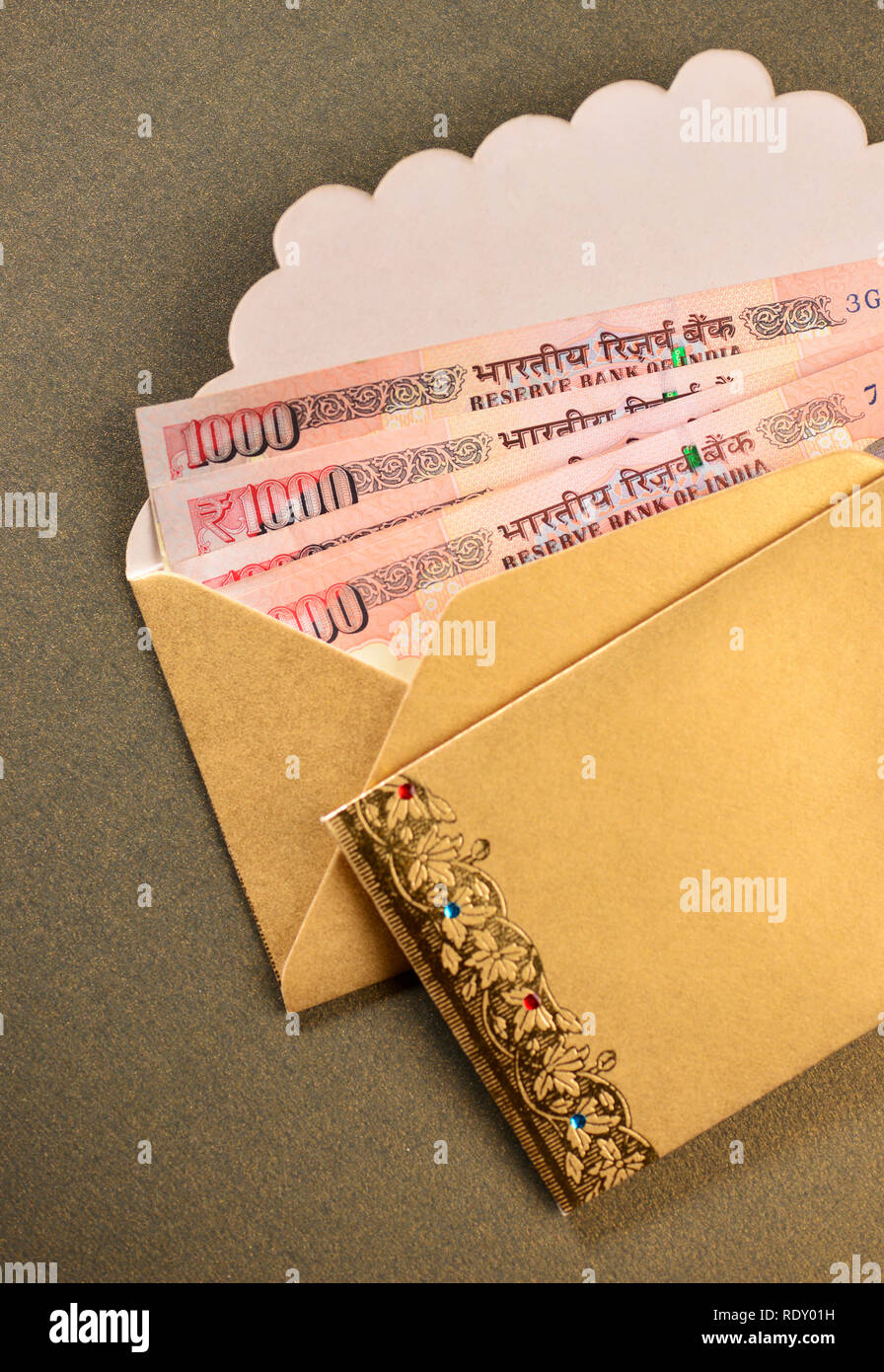 One thousand Indian Rupee notes in a golden envelope. Cash gifting. Old ...