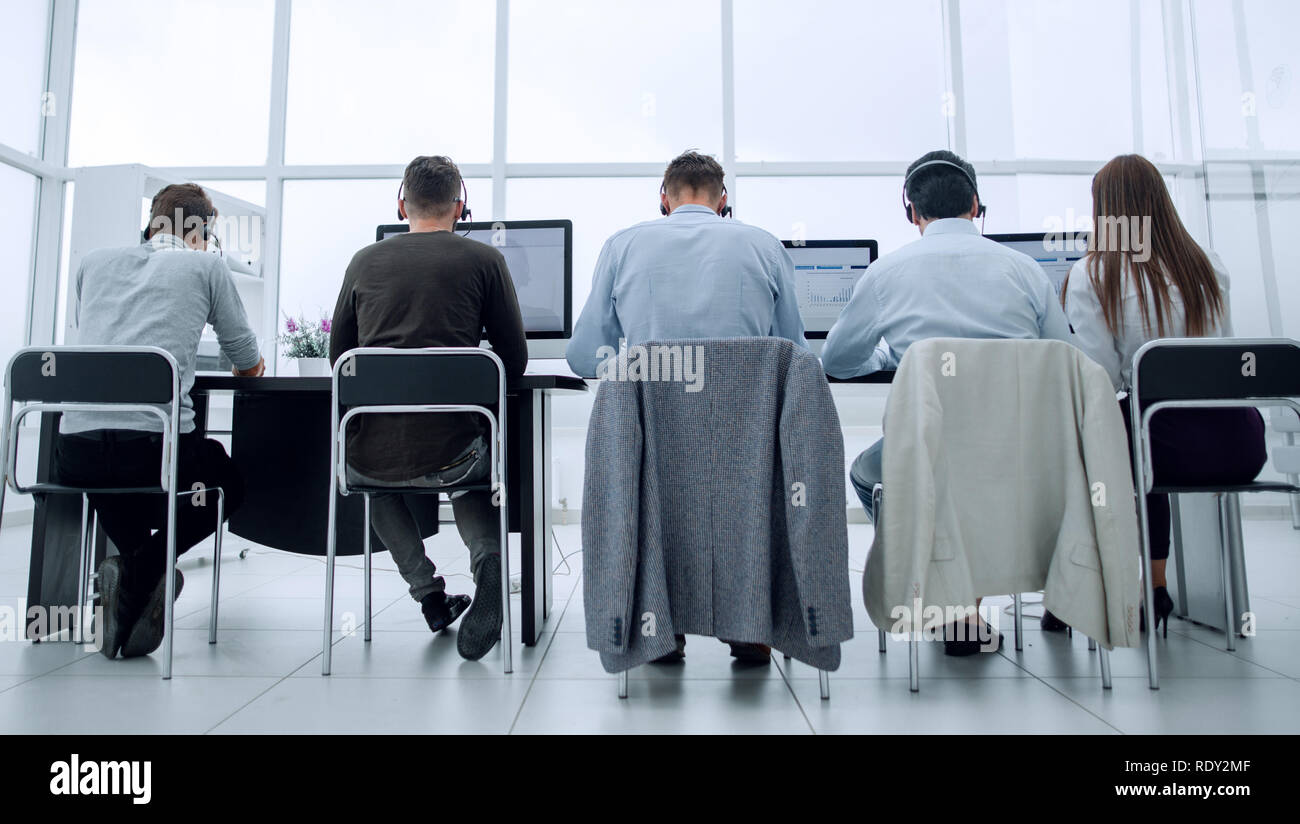 rear view.a group of call center employees sitting at the Desk Stock ...