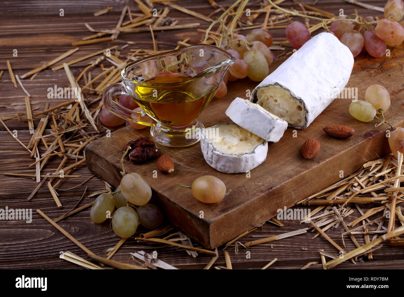 Cheese with white mold. Saint-Moret-de-Touraine on straw with grapes ...