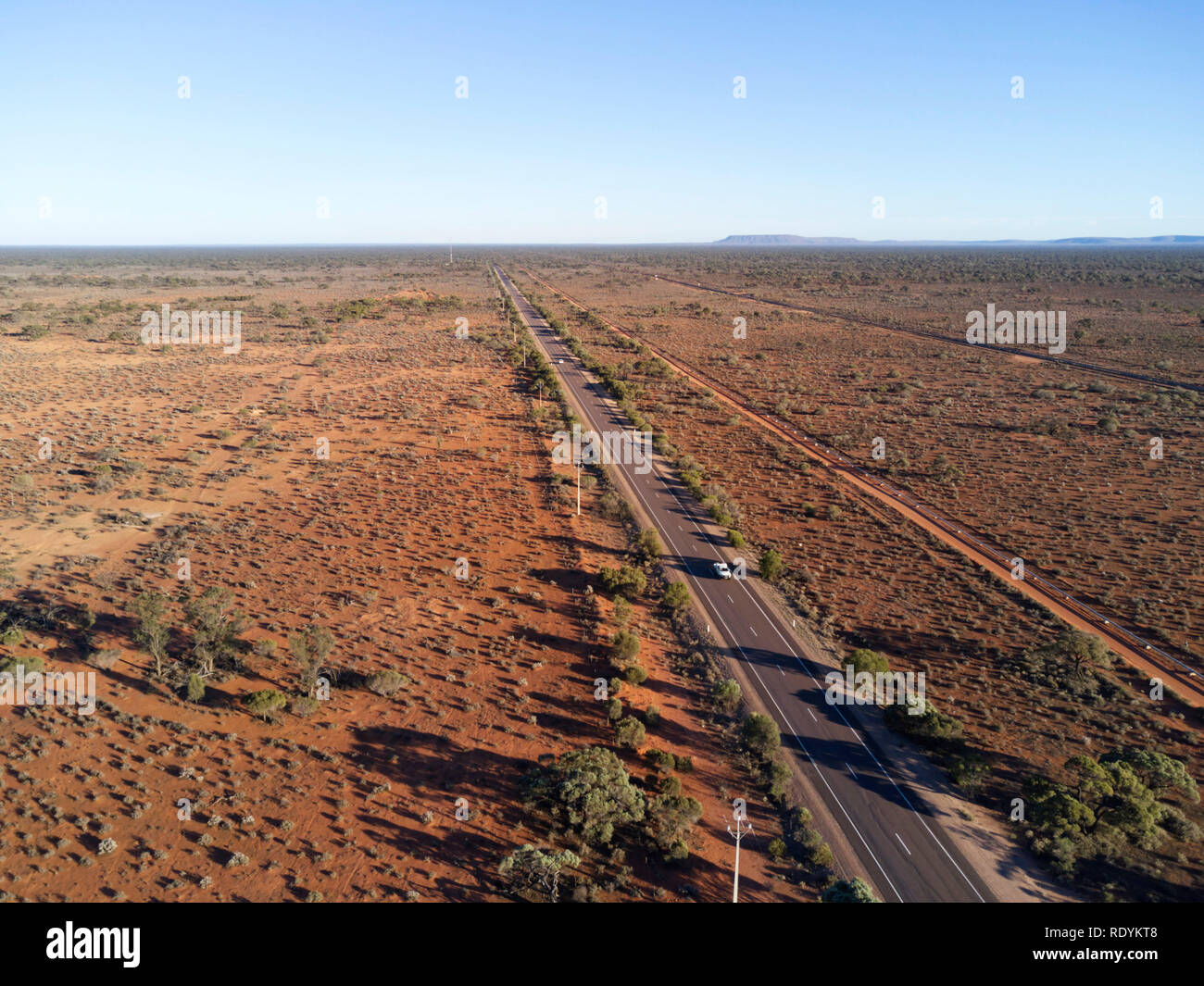 Aerial of the Stuart Highway passing through flat arid desert country ...