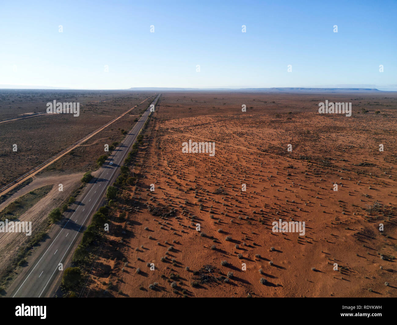 Aerial of the Stuart Highway passing through flat arid desert country ...
